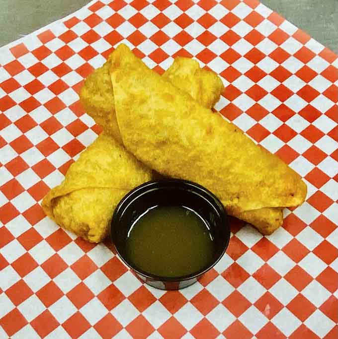Crispy egg rolls served golden brown with dipping sauce, adding an unexpected twist to the menu lineup.