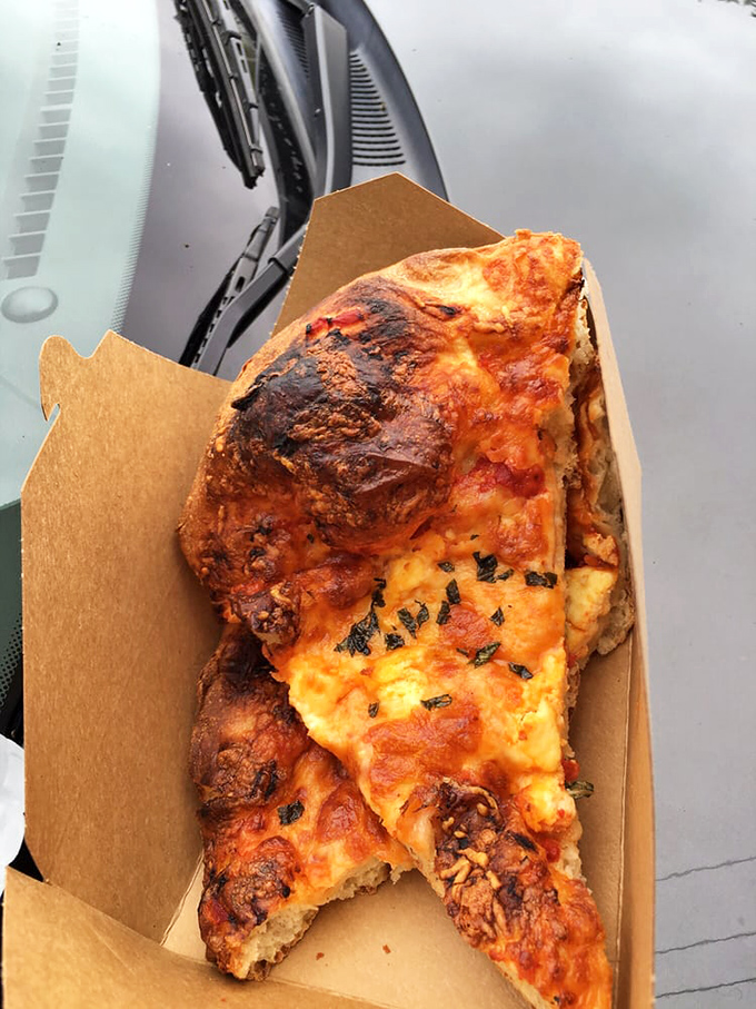 Pizza "slab" that makes regular pizza look like it's not even trying &ndash; half-eaten because nobody has the willpower to wait for photos.