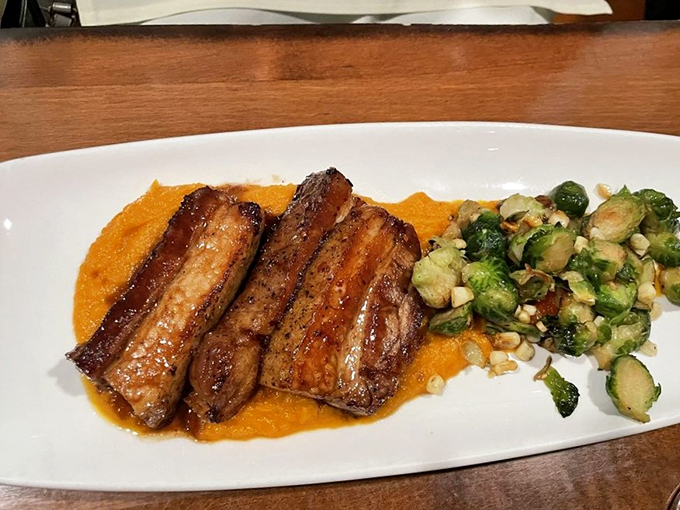Pork belly so good, it'll make you squeal with delight. Nestled on a vibrant orange puree with Brussels sprouts, it's a flavor combination that's music to your taste buds.