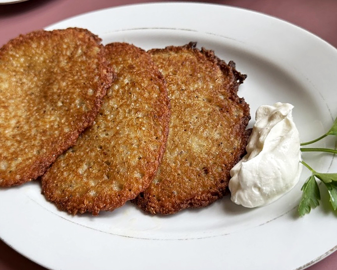Golden-brown placki that crackle with each bite, served with a dollop of sour cream that melts into creamy perfection.