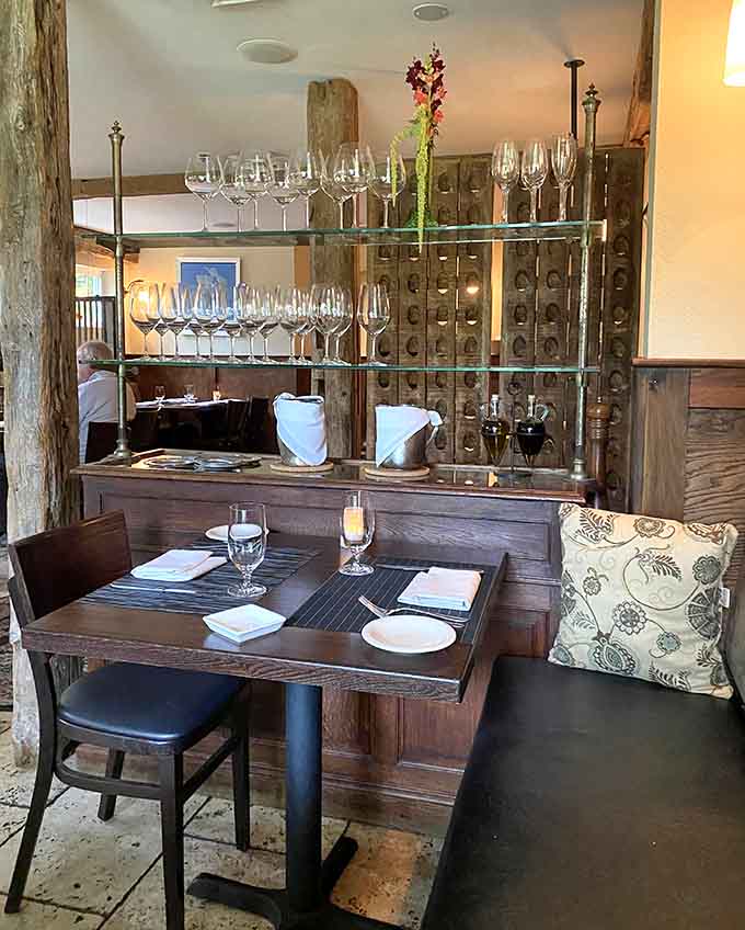 Intimate booth seating with wine storage that suggests this place takes beverages as seriously as food.