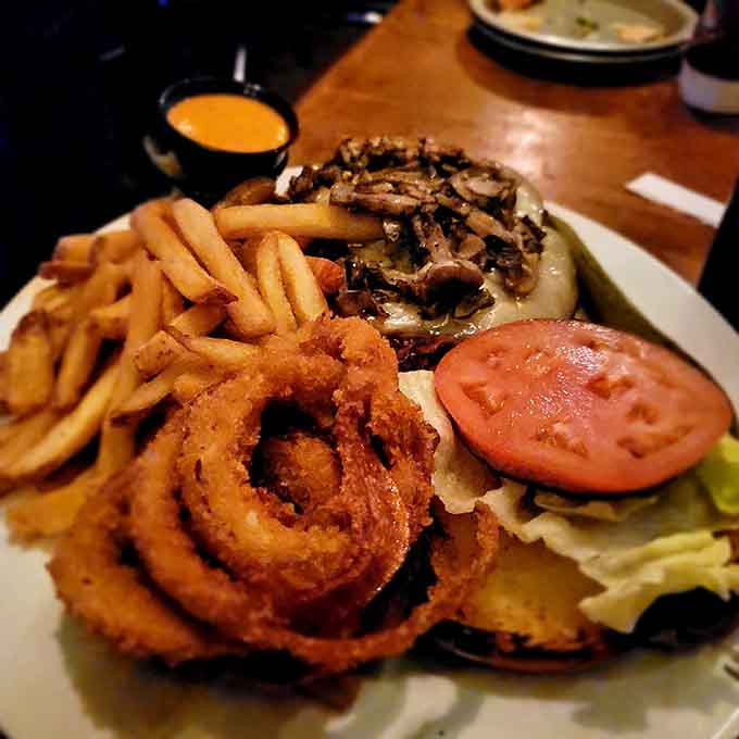 This burger comes with crispy onion rings and enough toppings to require both hands and maybe a strategy.