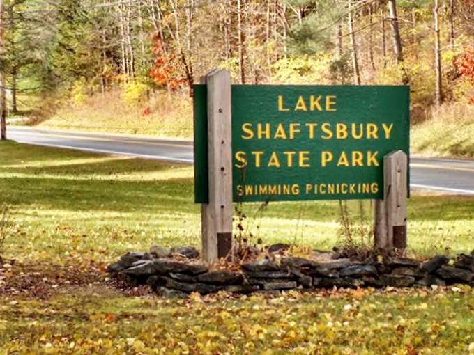 The classic green park sign welcomes visitors like an old friend, promising swimming and picnicking adventures ahead.