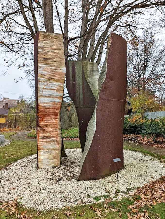 Three weathered slabs emerge from their gravel bed like ancient monoliths, their textured surfaces telling stories of time and elements.