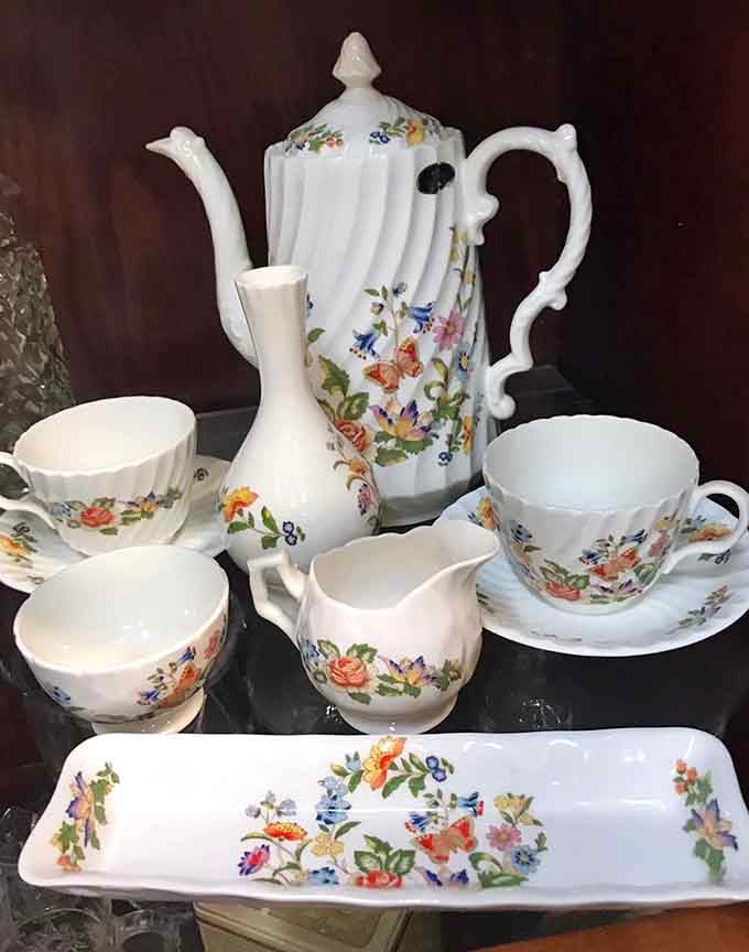 Floral tea sets sit ready to serve, looking like they've hosted more elegant conversations than most of us will have.
