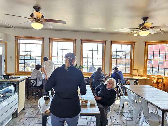 Diners enjoy their meals in a bright, welcoming space where every seat offers a connection to the water just outside.
