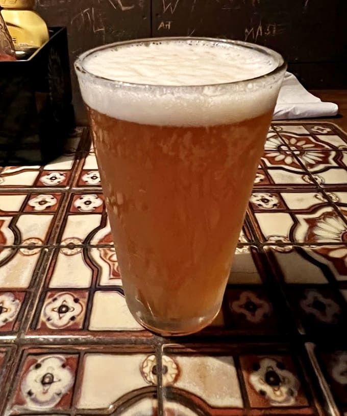 That perfect beer pour with a proper head, cold enough to make condensation race down the glass like it's late for something.