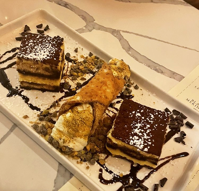 Dessert nirvana: tiramisu squares and cannoli sharing a plate, drizzled with chocolate and dusted with powdered sugar &ndash; resistance is futile.