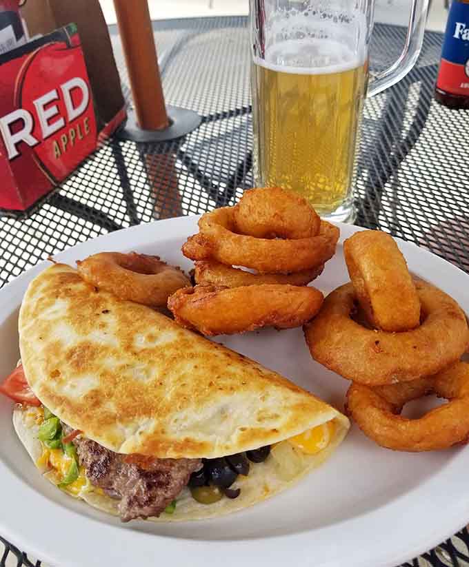 A taco paired with onion rings demonstrates the menu's versatility beyond their famous burger offerings.