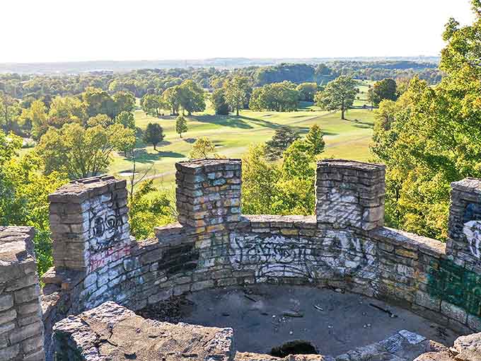 Graffiti-marked stone battlements frame a sweeping vista of Butler County's undulating landscape, golf course greens punctuating the distance.