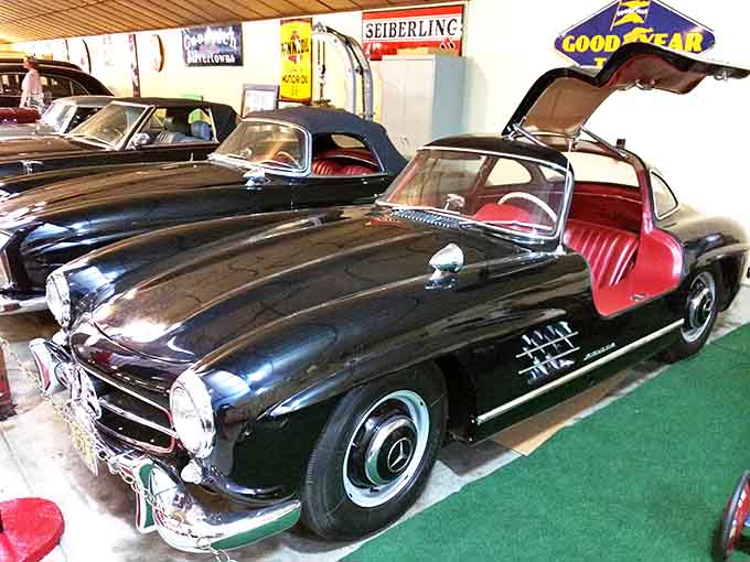 The Mercedes-Benz 300SL's gullwing doors reach skyward like a mechanical angel, its sleek design still turning heads decades after rolling off the assembly line.
