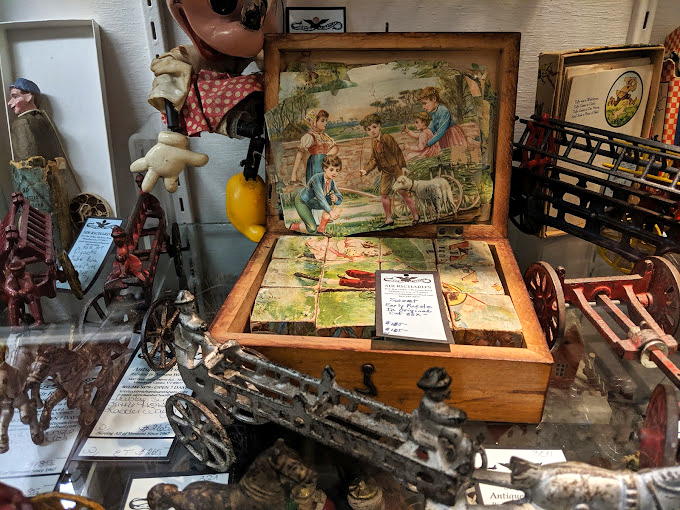 A charming wooden puzzle box shares space with miniature treasures, each piece waiting to spark joy in a new home.