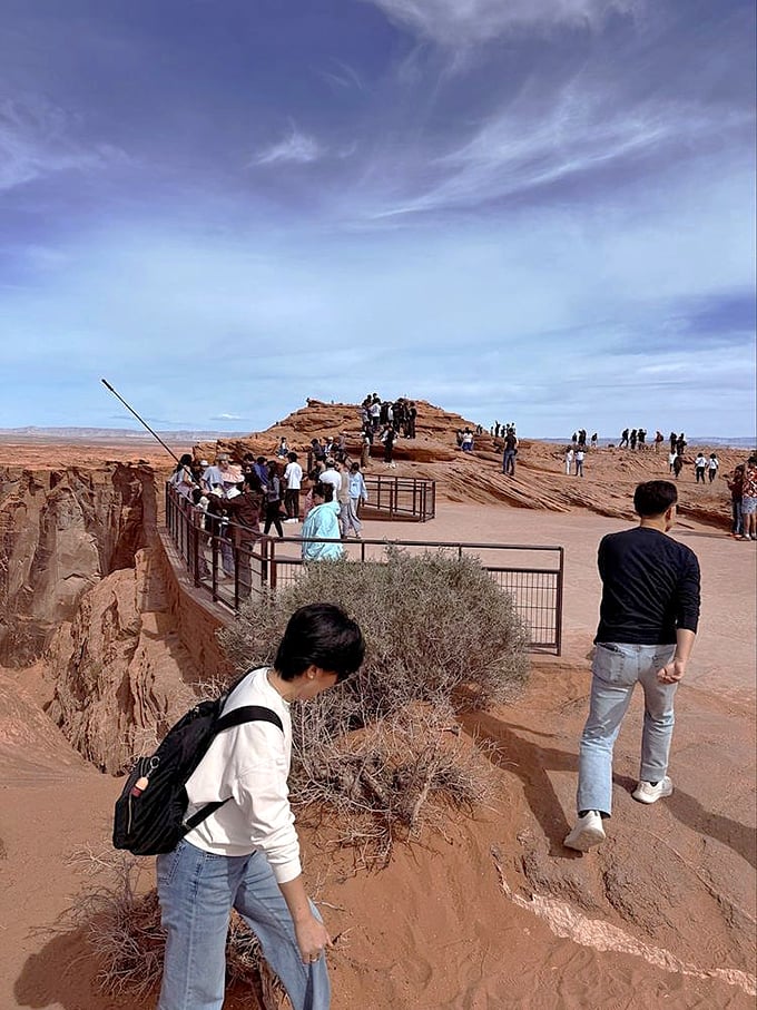 The human parade along nature's balcony - visitors navigate the viewing area, each seeking their own perfect vantage point.