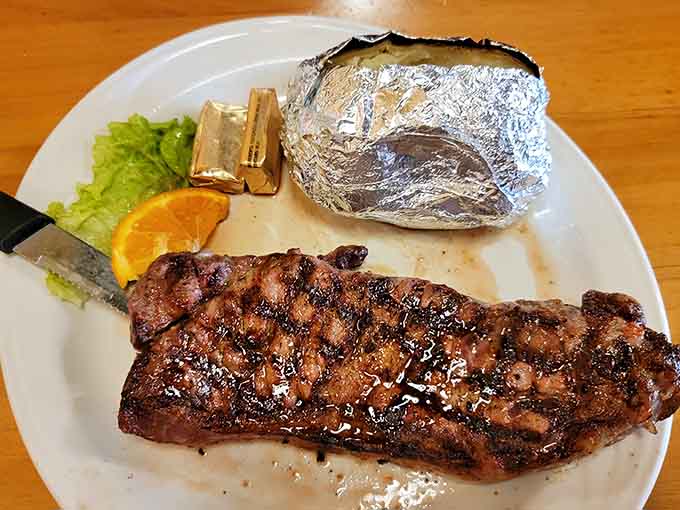 That New York strip is charred to perfection and ready to make your carnivorous dreams come true, foil-wrapped potato included.
