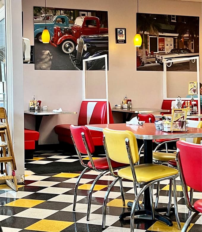 The dining room channels pure 1950s energy with vintage car photos and retro seating that makes every meal feel like a special occasion.