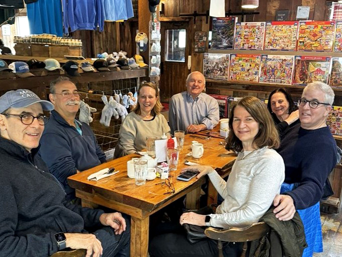 Happy diners gathering around wooden tables &ndash; where conversations flow as freely as the maple syrup and strangers become friends.