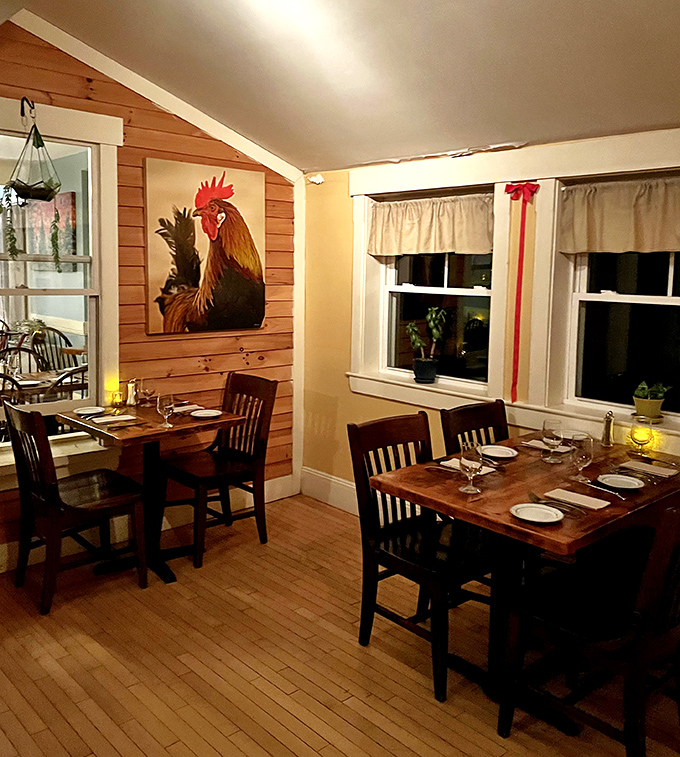 Warm wood paneling and a statement rooster painting create a dining space that feels both sophisticated and comfortably rural.