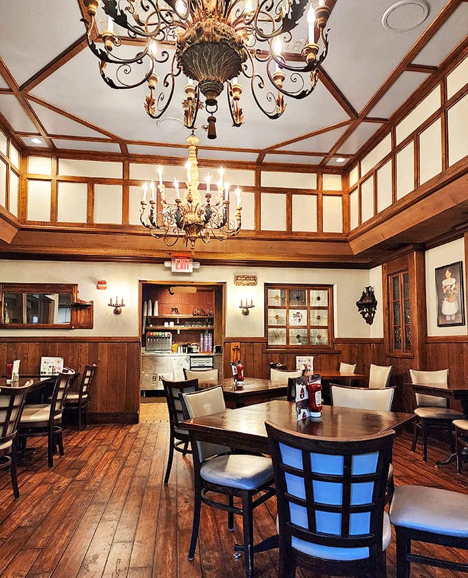 Elegant chandeliers and wood-paneled walls create a dining room that feels both regal and welcoming.