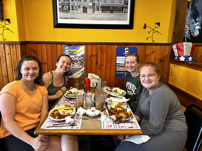 Happy faces around a table loaded with breakfast bounty &ndash; the universal language of "we ordered exactly right."