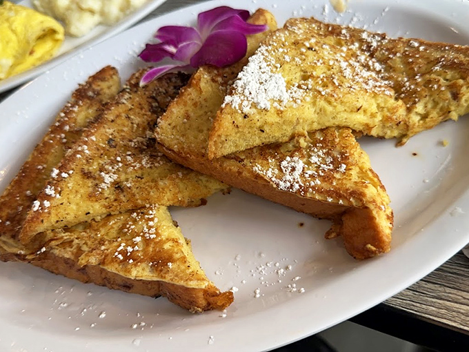Golden French toast triangles dusted with powdered sugar &ndash; crisp edges giving way to custardy centers that transform ordinary bread into morning magic.