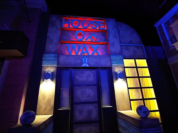 The House of Wax entrance beckons with its illuminated windows, promising a disorienting journey where nothing and no one is quite what they seem.