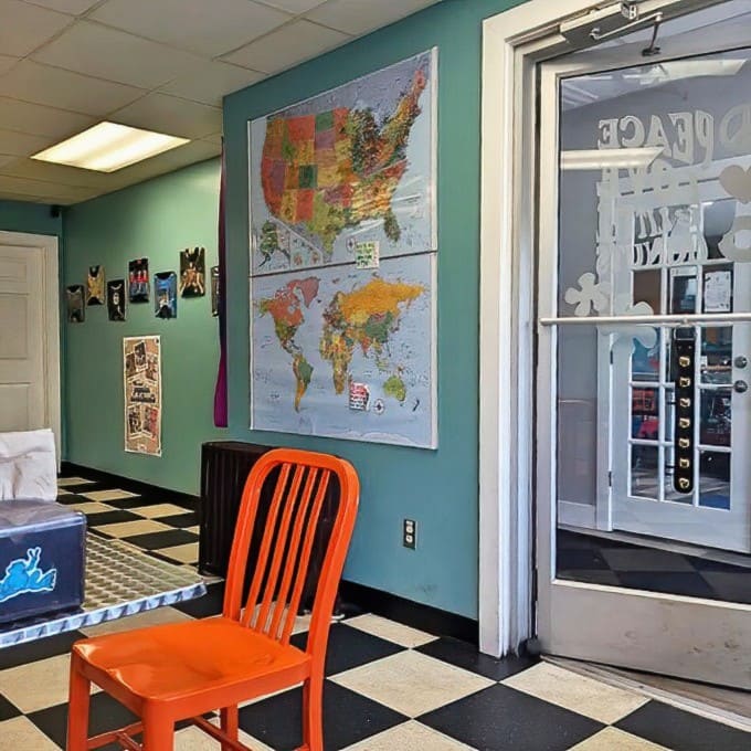 Maps adorn the turquoise walls, perhaps suggesting that peace, love, and donuts are universal languages worth spreading worldwide.
