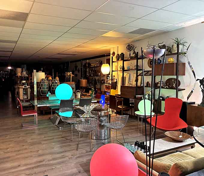 The shop transforms at night, with strategic lighting highlighting sculptural lamps and creating an almost gallery-like atmosphere for furniture appreciation.