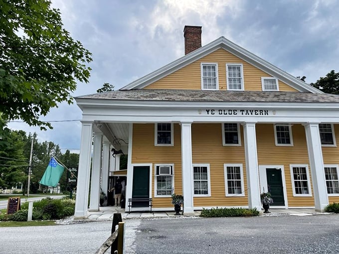 The tavern's historic fa&ccedil;ade glows with welcome, its white columns and yellow clapboard a beacon for hungry travelers seeking authentic New England fare.