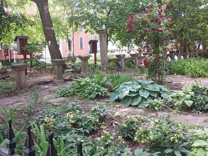 Nature provides a tranquil counterpoint in the prayer garden, where stone benches and lush greenery offer peaceful respite from urban life.