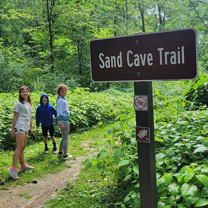 The Sand Cave Trail sign stands as a portal to adventure, promising discoveries that can't be found on any digital screen.