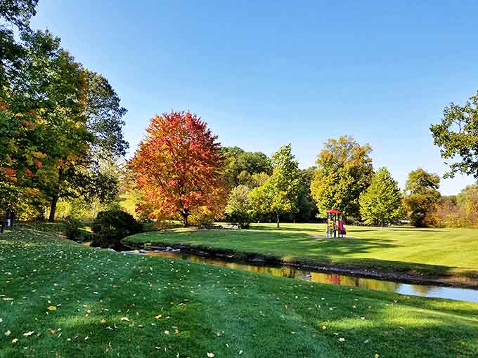 A gentle stream meanders between manicured banks, reflecting blue skies and offering peaceful moments of natural meditation.