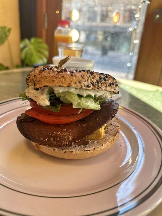 A simple yet perfect creation &ndash; cream cheese, greens, and tomato on a toasted bagel, proving sometimes less truly is more.