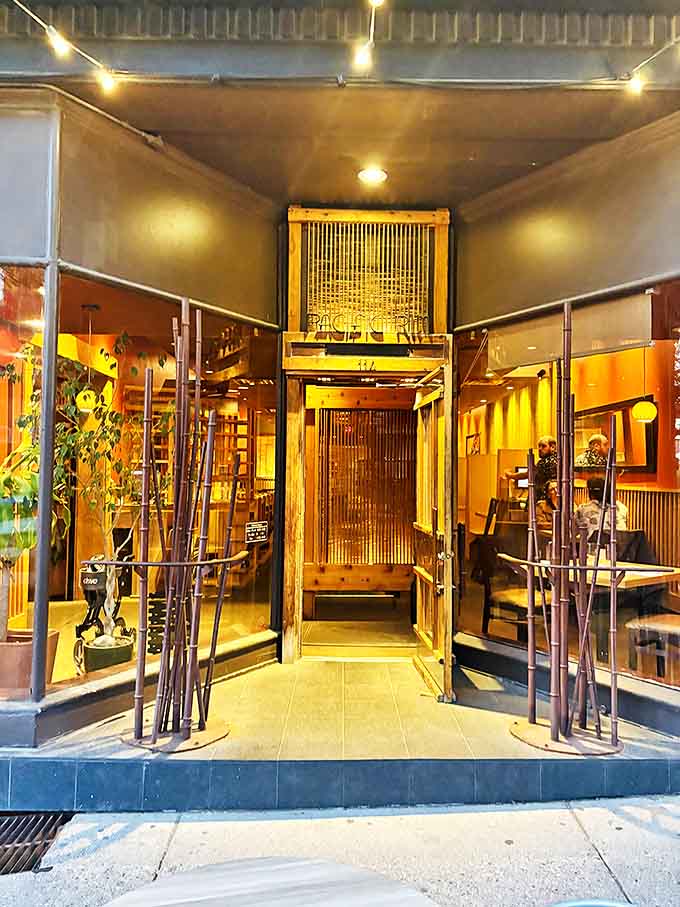 The entrance corridor feels like a portal to another world, where bamboo elements and golden light signal the start of your culinary journey.