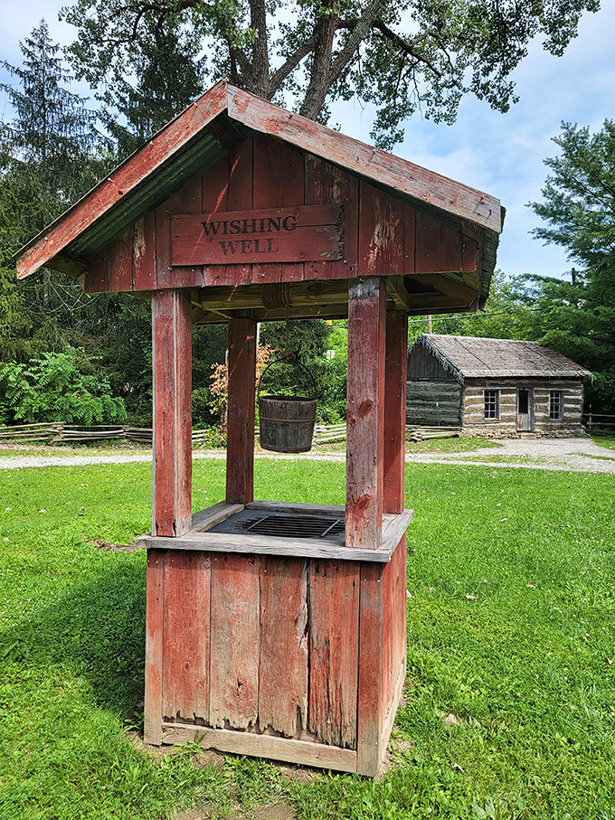 This charming wishing well invites visitors to toss a coin and dream, with the historic log cabin providing a perfect backdrop.