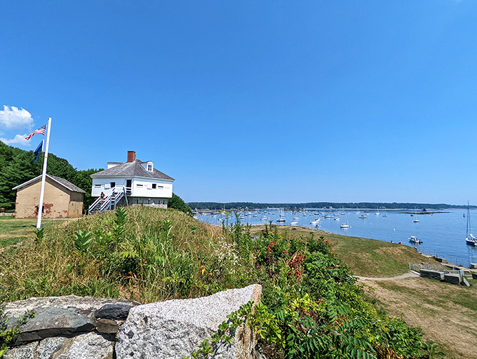 A postcard-perfect scene: Fort McClary's white buildings stand sentinel over a harbor dotted with sailboats, like a maritime snow globe come to life.