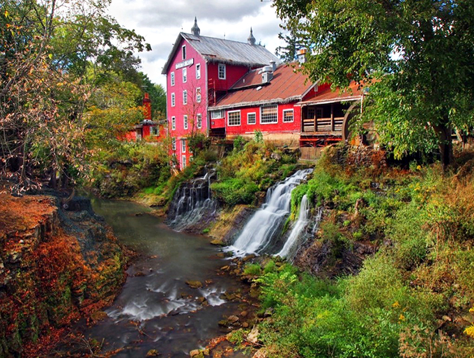 A postcard come to life! Clifton Mill stands proudly over cascading falls, its vibrant red exterior a siren call to history buffs and pancake lovers alike.