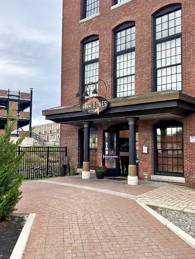 Housed in a historic brick building, Fish Bones Grill's welcoming entrance promises seafood treasures within its warm, inviting walls.