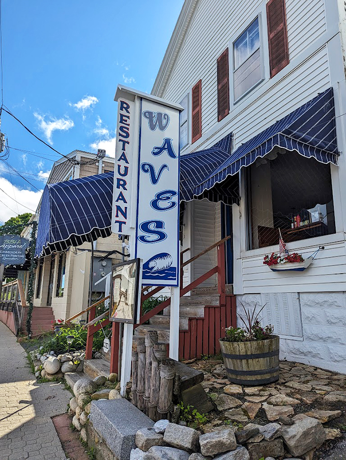 Classic New England charm meets maritime whimsy at Waves, where navy awnings and weathered wood create an inviting coastal welcome.