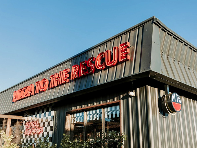 The bold red neon sign against industrial-modern architecture sets the tone - this isn't your average pizza joint. Welcome to where comfort food meets compassion.