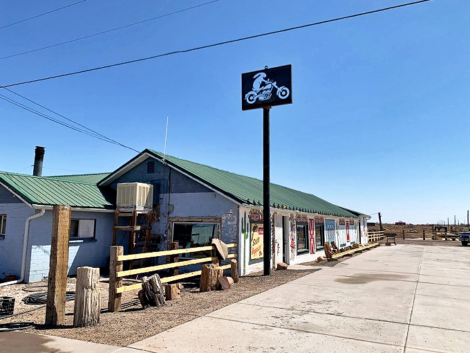 A slice of Route 66 nostalgia stands proudly against the Arizona sky, complete with vintage motorcycle sign and rustic charm.