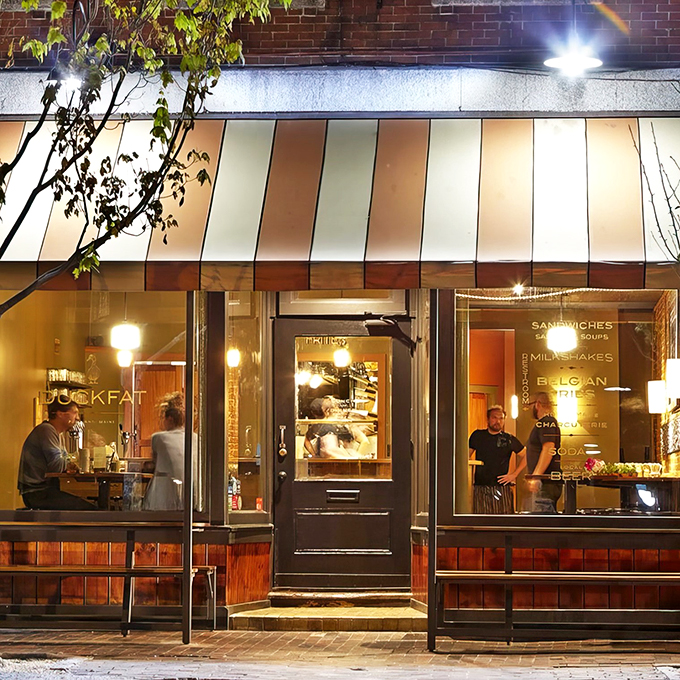 A cozy storefront that beckons like a warm hug, complete with striped awning and golden lighting that says "come in, stay awhile."