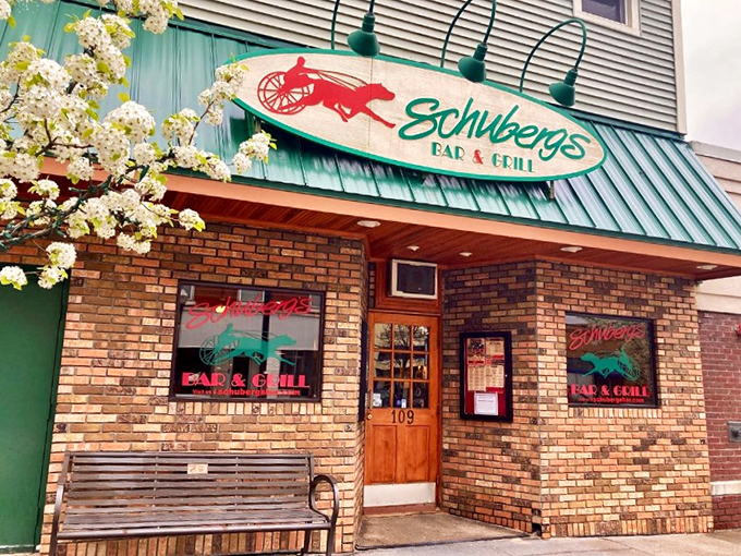 A slice of Americana awaits behind that iconic green awning, where spring blossoms frame decades of delicious history.