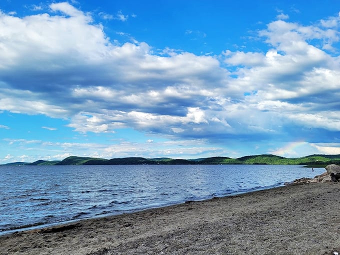 Lake Champlain's canvas: Where Bob Ross meets Mother Nature. Clouds dance above, mountains whisper in the distance, and the beach beckons with a siren song of serenity.