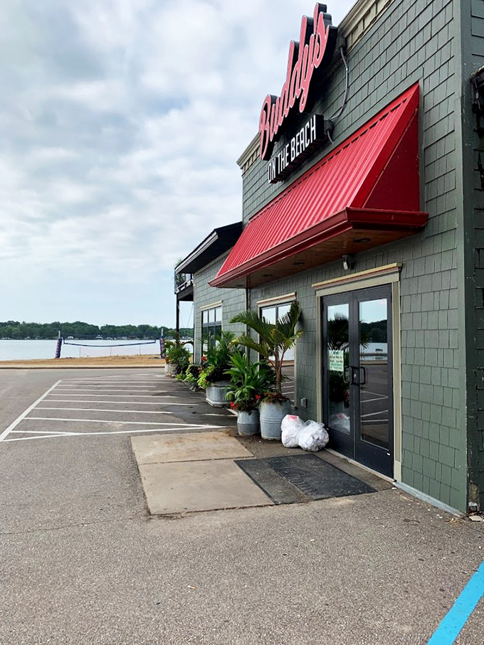 A sage green building with a bold red awning and tropical palm trees - because Michigan summers deserve a touch of paradise.