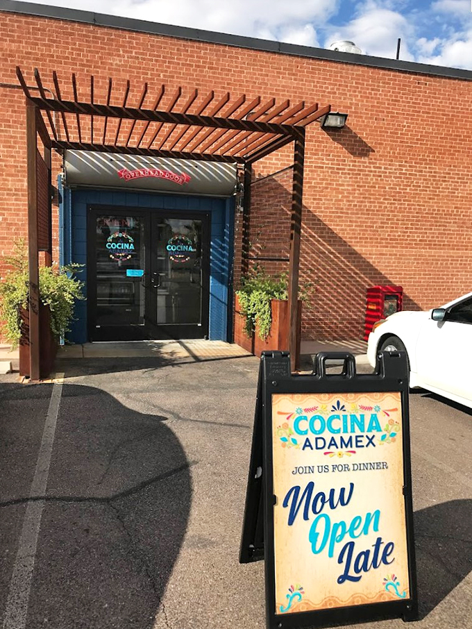 The inviting entrance of Cocina Adamex beckons with its wooden pergola and bright blue doors, like a warm Mexican hug waiting to happen.