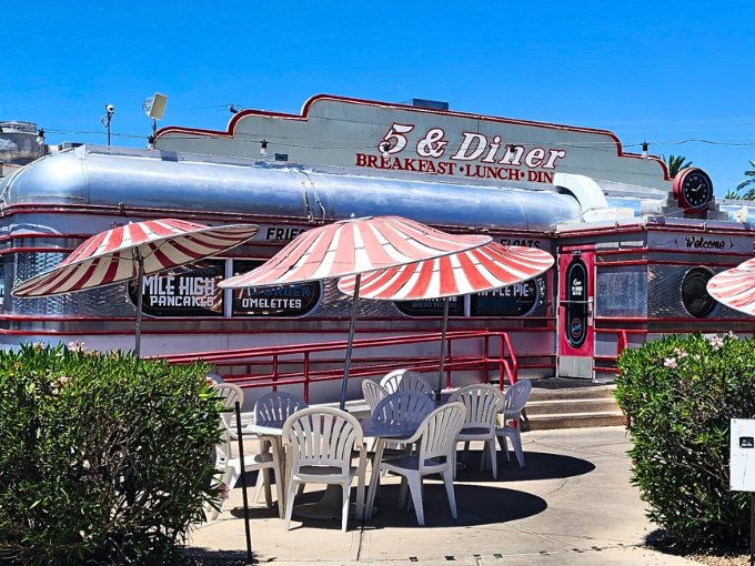 The gleaming chrome exterior of 5 & Diner shines like a time capsule from the 1950s, complete with retro signage promising mile-high pancakes and classic comfort food. Photo credit: Robert Haines