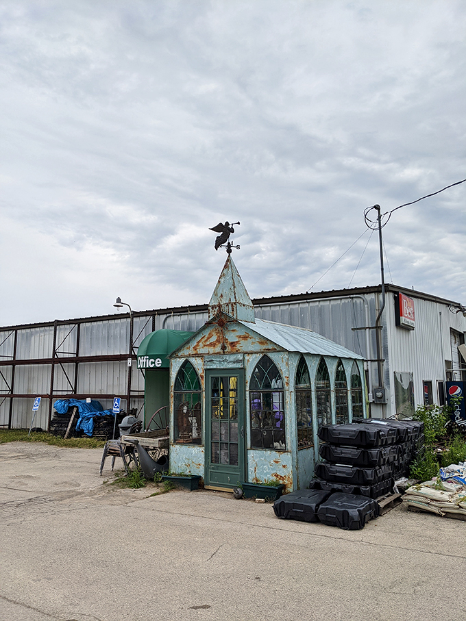 Welcome to the Twilight Zone of home decor! This weathered gazebo guards the entrance to M Schettl Sales, where whimsy meets practicality in a delightful dance of the bizarre.
