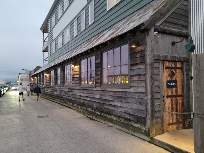The weathered wooden exterior of Scales feels like a secret maritime hideaway, with warm lights beckoning seafood lovers through its rustic door. Photo credit: Rocky's World
