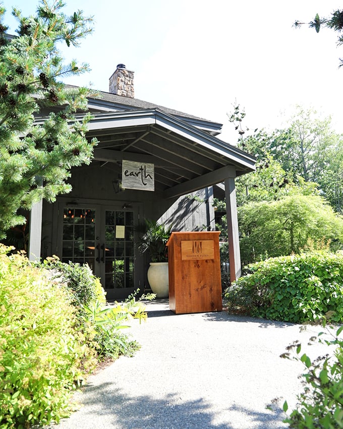 A rustic welcome awaits at Earth's entrance, where pine-scented breezes and climbing vines create nature's perfect prelude to dinner. Photo credit: Earth at Hidden Pond