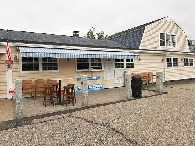 Classic New England charm meets coastal comfort at this cream-colored haven, where blue-striped awnings welcome you like a maritime hug. Photo credit: Wayne Penn